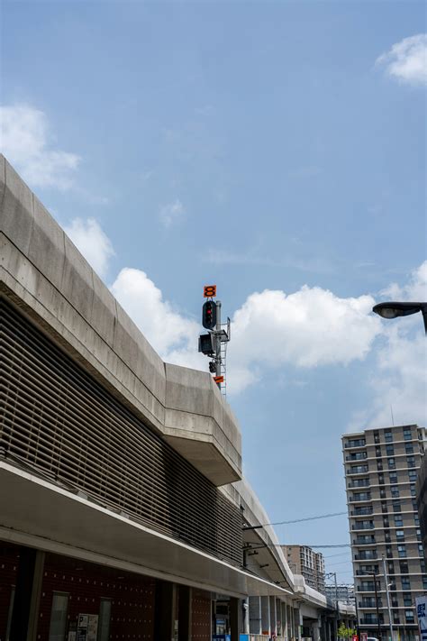 A Traffic Light On A Pole In Front Of A Building Photo Free City