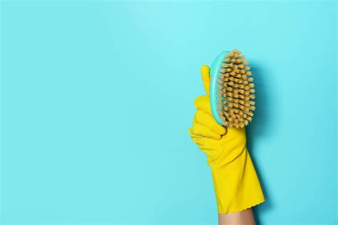 파란색 배경에 브러시를 들고 장갑에 손을 공간을 복사합니다 청소 집 청소 화장실 개념 청소 서비스 개념 가정용 화학 적 세척 제품 브러시 및 용품 가사 집안일에 대한 스톡