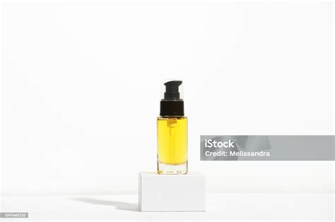 받침대에 디스펜서가 있는 브랜드가 없는 병 헤어 오일투명 유리 용기 손상된 모발에 대한 수분 보습 화장품 과 미용 개념 공간을 복사합니다 흰색으로 분리 0명에 대한 스톡