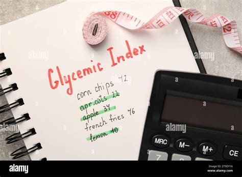 Glycemic Index Notebook With Information Measuring Tape And Calculator On Light Grey Table Glycemic Index Notebook With Information Measuring Tape And Calculator On Light Grey Table