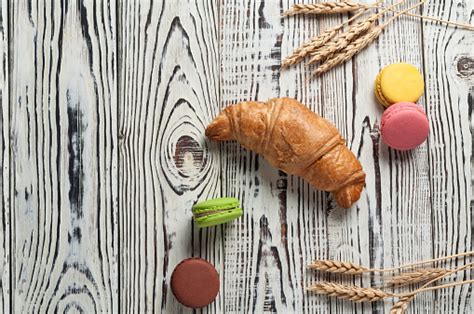 오래된 흰색 소박한 나무 테이블에 밀과 다양한 다채로운 마카롱 근처 하나의 전체 구운 크루아상 갈색에 대한 스톡 사진 및 기타 이미지 Istock