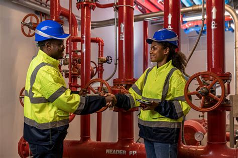 화재 진압 시스템 및 화재 장비를 점검하는 엔지니어 또는 기술자 작업 엔지니어는 물 스프링클러 배관 및 화재 경보 제어 시스템에 대한 빨간색 발전기 펌프를 확인합니다 불에