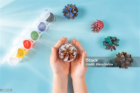 Diy와 아이의 창의력의 개념 단계별 지시 그림 소나무 콘 그림이 그려진 소나무 콘을 들고 있는 3단계 어린이의 손 어린이 크리스마스와 새해 공예 Diy에 대한 스톡 사진