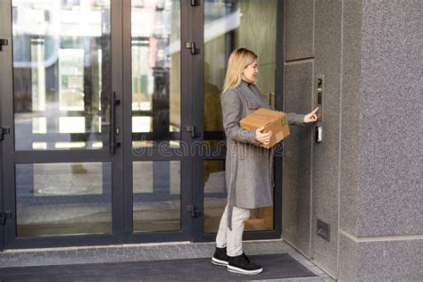 Happy Woman Ringing On Doorbell At Building Entrance Using Intercom Stock Image Image Of