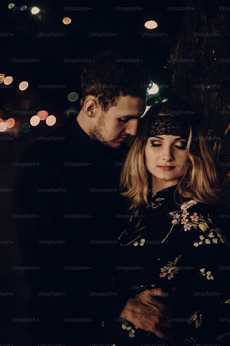 저녁 도시 거리에서 포옹하는 열정적인 연인들 도시의 불빛에 부드럽게 포옹하는 사랑에 빠진 세련된 커플 현대 여자와 남자 로맨틱 프랑스 분위기의 순간 사진