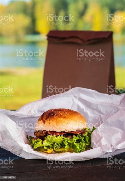 소고기 양상추 피클 토마토 양파 링을 나무 테이블에 얹은 육즙이 풍부한 치즈버거 클래식 길거리 음식 구운 햄버거 고기에 대한