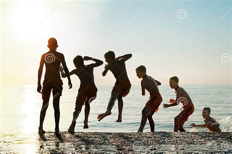 Sequence Of Jump Moments Of Schoolboy Jumping From Pier Into Sea Doing