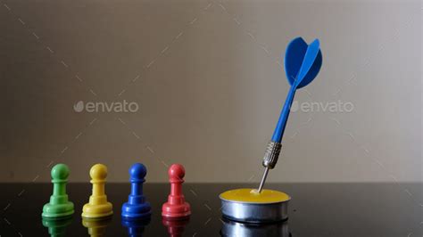 Close Up Shot Blue Dart Arrow And Plastic Board Game Pieces Figures Pawns Puppets Stock Photo