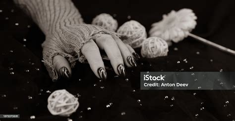 검은 색 배경에 보라색 매니큐어와 세련된 니트 장갑에 성인 여성의 손 손톱에 디자인으로 인식 할 수없는 사람을 자르기 관심과 아름다움의 개념 흑백 검정색 배경에 대한 스톡