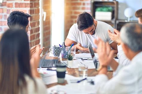 행복하고 자신감 넘치는 미소를 짓는 비즈니스 근로자 그룹 사무실에서 그들 중 한 명이 박수를 보내는 얼굴에 미소를 지으며 함께 일하기 경영자에 대한 스톡 사진 및 기타