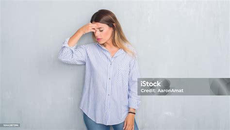 코와 눈 피로 두통 느낌 바르고 피곤된 패션 비즈니스 옷을 입고 회색 그런 지 벽에 젊은 성인 여자 스트레스와 좌절 개념입니다 갈색 머리에 대한 스톡 사진 및 기타 이미지