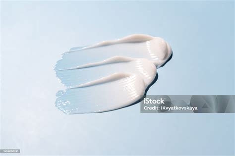 파란색 배경에 흰색 크림의 질감입니다 모이스처 라이저의 얼룩이 닫힙니다 로션 견본 뷰티 스킨 케어 제품 얼룩 얼룩 파란색 배경에