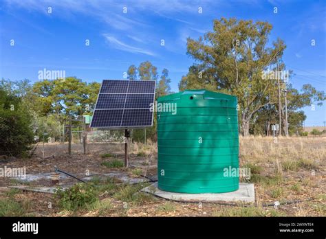 large green plastic storage tank with solar panes connected to a