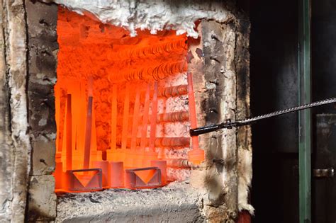 작업자는 금속 경화를 위해 전기로에서 집게로가 열 된 부품을 꺼내 냅니다 밸브 제조 공장에서 중공업 분야의 고온에서 위험한 작업 가마 건축물 특징에 대한 스톡 사진 및 기타