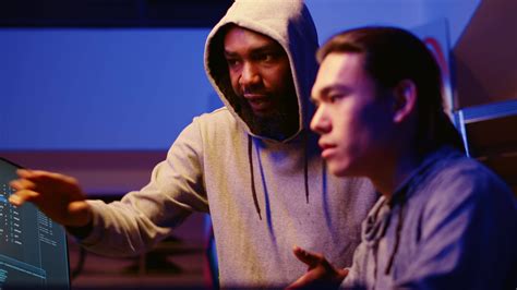 Bipoc Hackers In Dimly Lit Room Discussing Ways To Breach Defenses And
