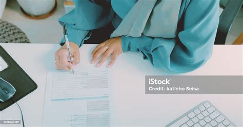 사무실에있는 여성의 손이 책상이나 테이블에서 문서 양식 및 계획을 작성합니다 컴퓨터 옆에서 서류 작업을하고 계약서에 서명하는 전문 사업가와 기업가를 닫으십시오 세금 양식에