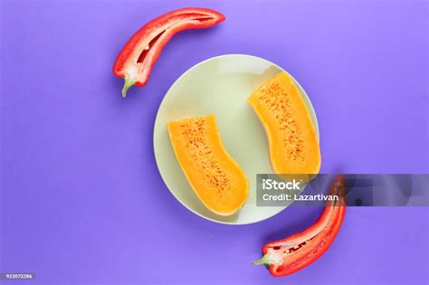녹색 플레이트에 호박과 붉은 고추 자주색 배경 야채 팝 아트 미니 멀리즘 자주색 배경 불가 리아 어 후추 디자이너 호박에 오렌지와 붉은 야채에 호박의 반쪽 채식주의 가을에