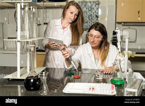 Team Of Two Female Laboratory Technicians Working In Chemical Or Pharmaceutical Laboratory Stock