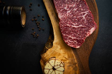 유토이미지 빈티지 나무도마위에 클로즈업 꽃등심과 후추 그리고 구운마늘