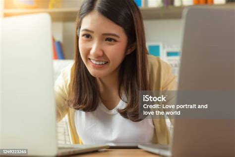 젊은 비즈니스 여성은 노트북 컴퓨터와 화상 통화 거실에서 행복과 웃는 얼굴로 동료와 상사에게 화상 회의를 사용하여 집에서 일합니다 일하는 소녀는 새로운 정상적인 삶을