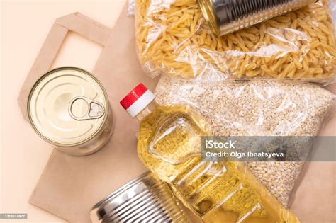 음식물 공급이 있는 종이 봉투는 밝은 노란색 배경에 식량 공급을 위기 진주 보리 파스타 통조림 식품 해바라기 기름 음식 배달 기부 코로나바이러스 0명에 대한 스톡 사진 및