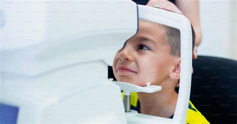 클리닉에서 시력을 확인하기 위해 기계를 사용하는 여성 안과 의사 안경점에서 장비와 의사가 눈동자를 테스트하는 어린 소년 안과 진료와 건강의 개념 사진 Unsplash