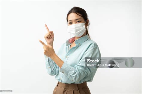젊은 행복한 아시아 여성은 흰색 배경에 고립 된 코로나 바이러스 감염 촬영을 방지하기 위해 위생 마스크를 착용 공간을 복사하기