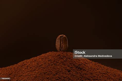 갓 구운 커피 콩은 갈색 배경에 한 줌의 분쇄 커피위에 서 있습니다 격리된 매크로 엽서 배너 공간을 복사합니다 갈색에 대한 스톡 사진 및 기타 이미지 Istock