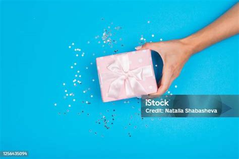 파란색 테이블 상단보기에 색종이로 장식 된 선물 이나 선물 상자를 들고 있는 여성 손 생일 이나 결혼식을 위한 플랫 구성 각도에 대한 스톡 사진 및 기타 이미지 Istock