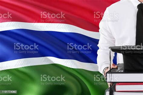 성공적인 Gambian 학생 교육 개념입니다 책과 감비아 국기 배경 위에 졸업 모자를 들고 감비아에 대한 스톡 사진 및 기타 이미지 Istock