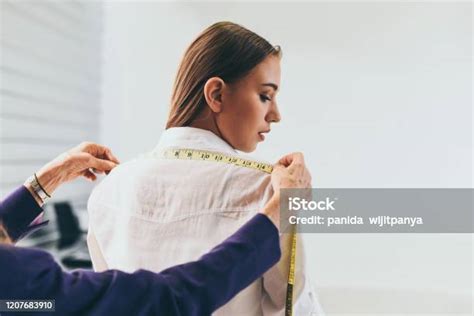 패션 디자이너 스튜디오 는 직물 소재 가위를 절단 하는 여성 디자이너 세련 된 쇼룸 디자이너 작업 전문 작업장에서 재단 모델 여성을 위한 의류를 측정 고급 의상에 대한 스톡