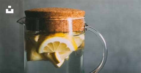 흑백 테이블 러너에 얇게 썬 레몬으로 채워진 투명 유리 투수 사진 Unsplash의 무료 마시다 이미지