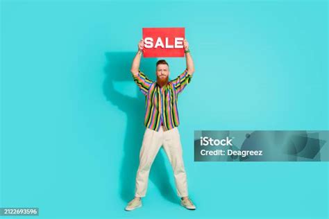 아쿠아마린 색상 배경에 고립 된 빨간 플래 카드 판매 프로모터를 들고 찡그린 펑키 미친 남자 힙 스터의 전체 길이 몸 사진 35 39세에 대한 스톡 사진 및 기타 이미지