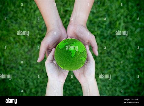 Environment Earth Day In The Hands Holding Green Earth On Bokeh Green