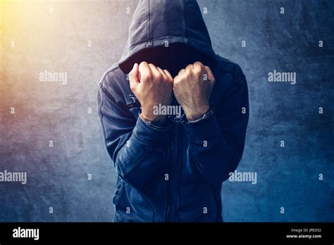 Arrested Computer Hacker And Cyber Criminal With Handcuffs Wearing