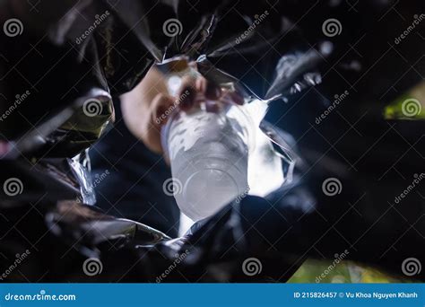 Man Throws Garbage Into A Garbage Can On The Street With A Worm View From The Inside Of The