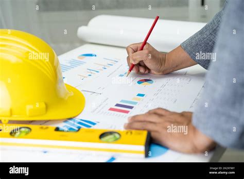 Asian Engineer With Architectural House Plan Project Blueprint Graph