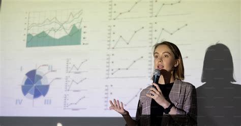 청중 앞에서 연설하는 동안 그래프가 있는 대형 화면에 서 있는 재무 분석가의 젊은 현대 중개인 사진 Unsplash의 백인 이미지