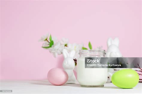 유기농 프로바이오틱 밀크 케피어 음료 또는 요구르트는 유리 용기에 색깔의 부활절 달걀 토끼와 분홍색 배경에 부활절 개념 프로바이오틱스와 함께 차가운 발효 우유 음료 0명에