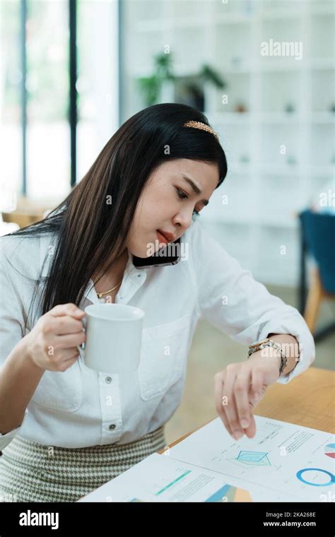 A Portrait Of A Beautiful Asian Employee Hustle Rushing While Watch At The Clock And Talking On