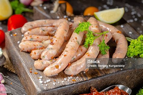 집에서 만든 핫도그 소시지 빨간색과 흰색 생선 고기에서 원시 빈티지 소박한 그릇 접시에 포크 나이프 숟가락 향신료 허브 스탠드와