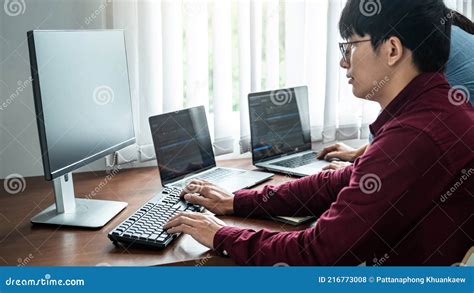 Asian Programmer Seen Typing Code For A User Interface Design On Dual Monitors Royalty Free