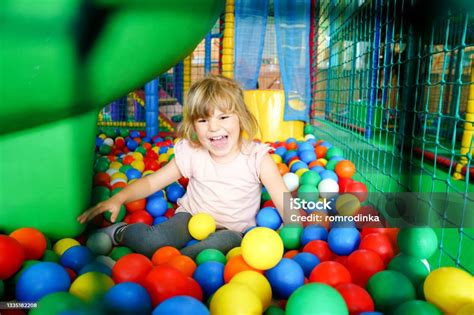 실내 놀이터에서 놀고있는 활동적인 어린 소녀 행복한 즐거운 유치원 어린이 등반 달리기 점프 및 다채로운 플라스틱 공으로 재미있게 지내고 있습니다 어린이를위한 실내 활동