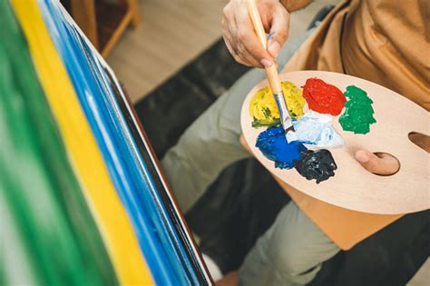 아시아의 남자 예술가는 붓과 다양한 아크릴 색으로 그림을 그리는 작업을 하고 있다 예술 개념으로 크리에이티브 스튜디오에서 캔버스에 있는 남자 예술가 화가 교실에 대한 스톡