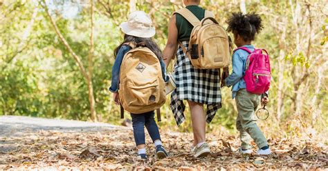 다양성의 그룹 여름 화창한 날에 숲 산에서 함께 배낭 하이킹을 하는 어린 소녀 친구들 세 아이가 앉아서 숲을 탐험하는 지도를 보며 즐거운 야외 활동을 하고 있습니다 사진