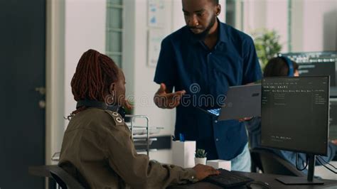 Software Developer Holding Laptop And Talking To Programer At Desk Stock Image Image Of Coding