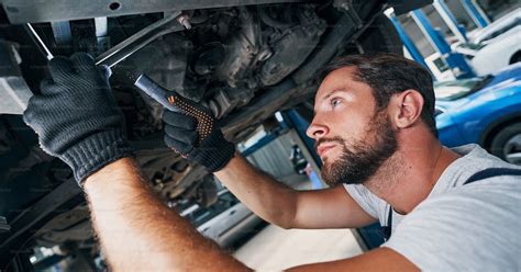 자격을 갖춘 남성 기술자가 차 아래에 서서 손전등으로 빛나는 동안 플로어팬을 확인합니다 사진 Unsplash의 성인 이미지