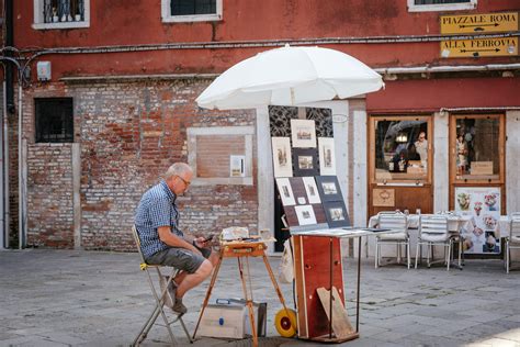 파란색과 흰색 체크 무늬 버튼 업 셔츠를 입은 남자가 의자에 앉아 사진 Unsplash의 무료 도시 이미지