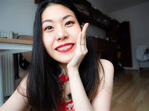 一张兴奋的亚洲中国年轻女子的画像坐在家里图片 包图网企业站