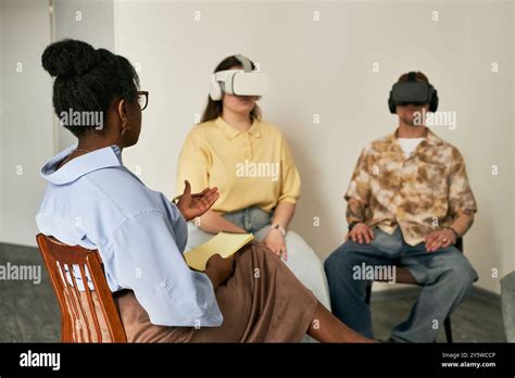 Three People Engaging Virtual Reality Experience In Education Setting With Headsets While